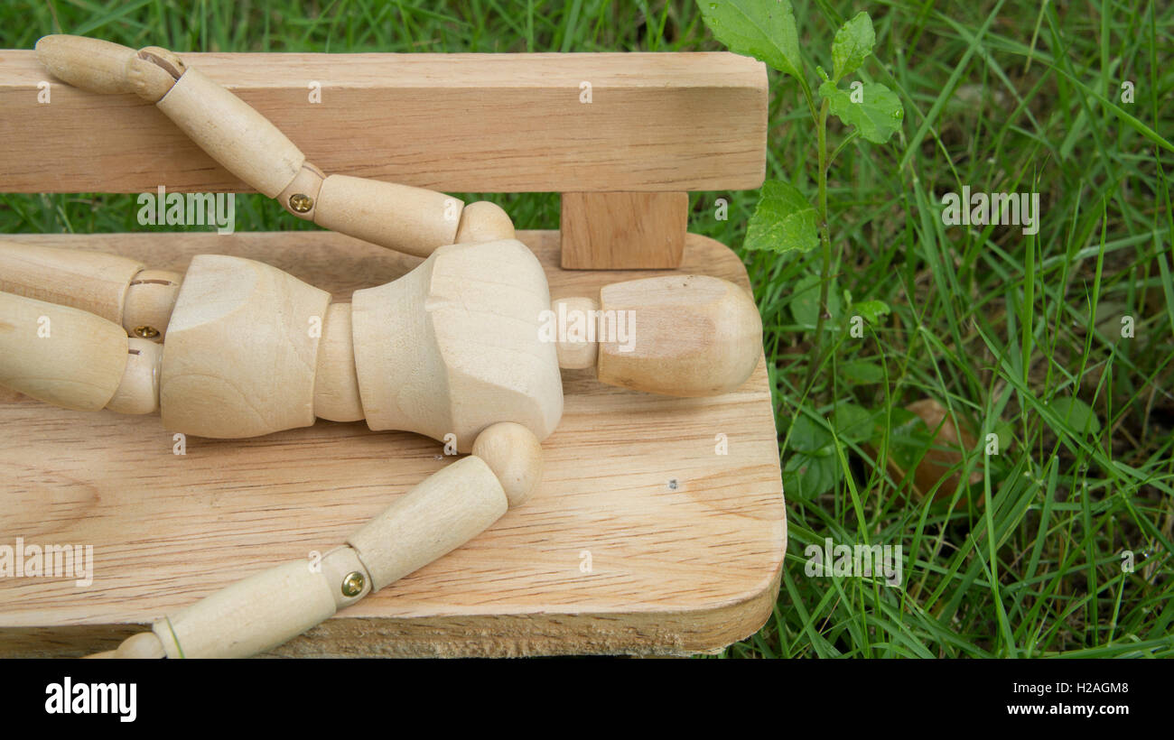 wooden human figure sleep bench garden Stock Photo - Alamy