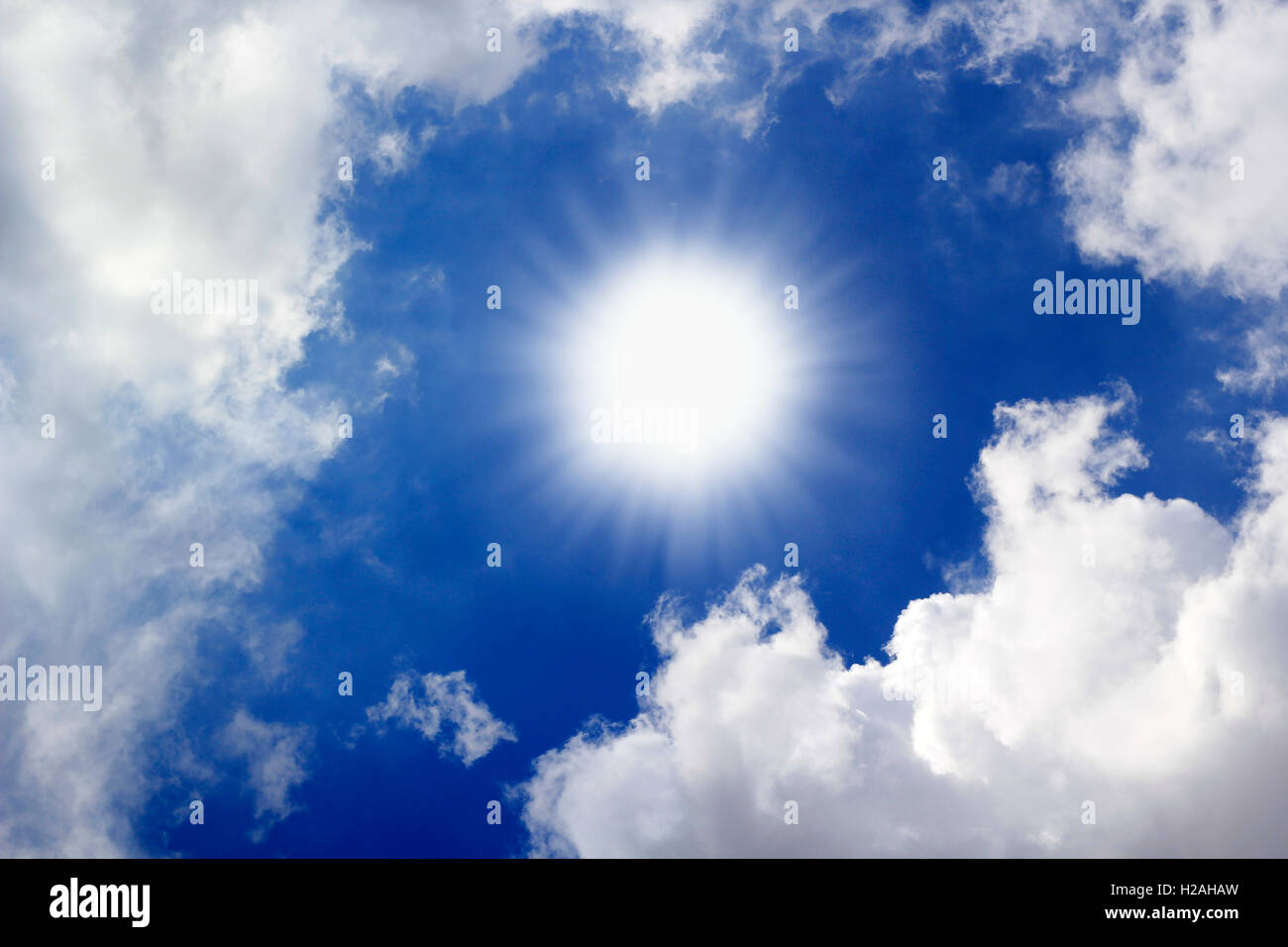 Sun shining through clouds on a blue sky Stock Photo - Alamy