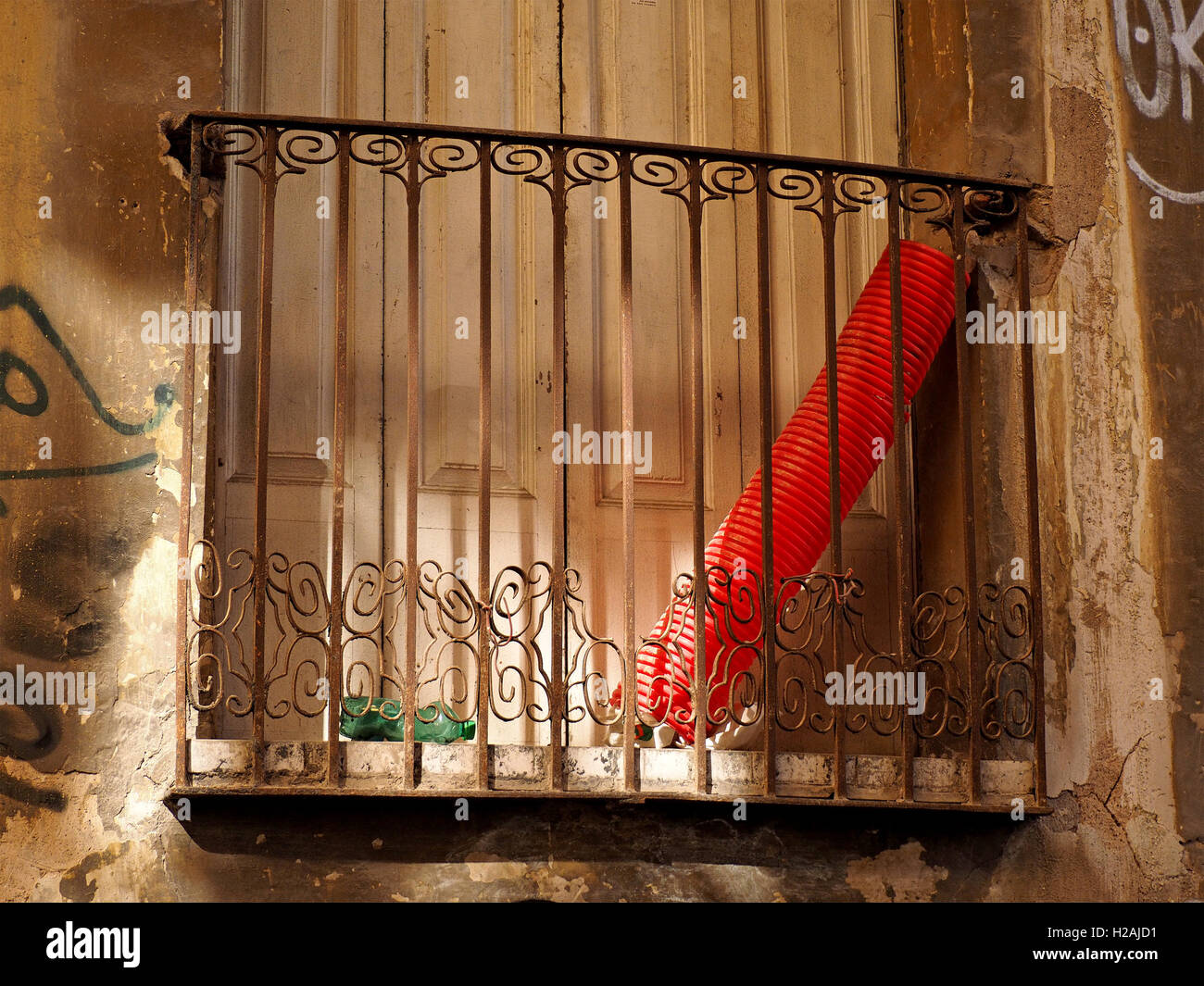 red flexible plastic utility conduit on shaded balcony with balustrade ...