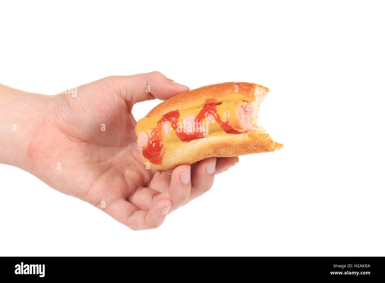 Hand holds bitten hotdog Stock Photo - Alamy