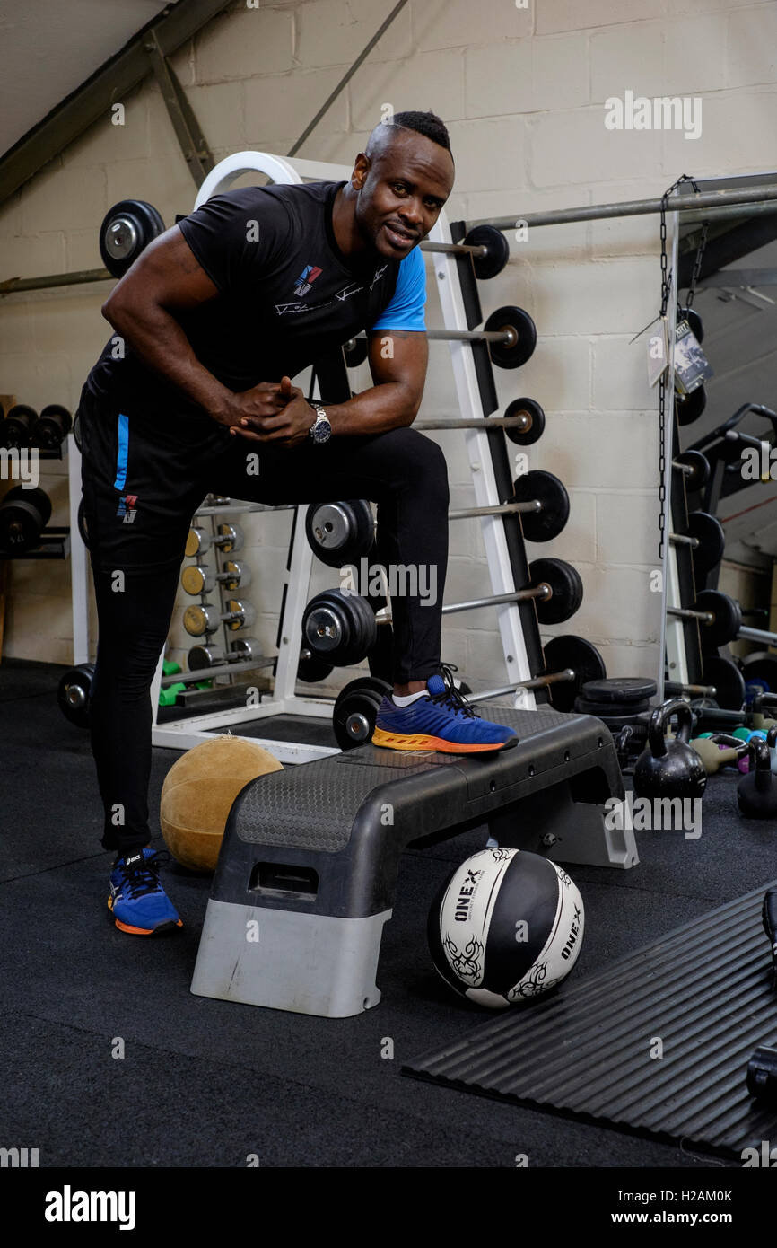 young male poses for a portrait whilst working out in a gym england uk ...