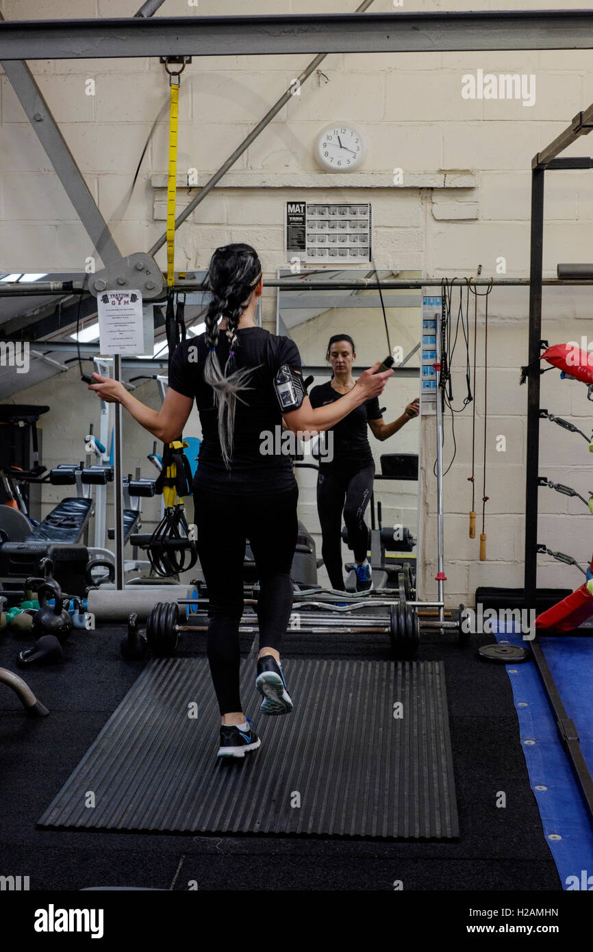 young female working out in a gym using a skipping rope england uk ...