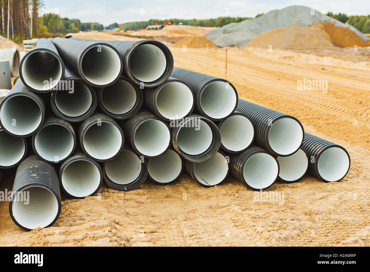 pile of big pipes on construction site Stock Photo - Alamy