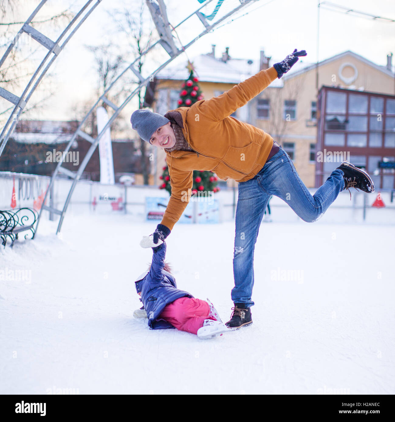 Young funny father and adorable little girl on a skating rink Stock ...