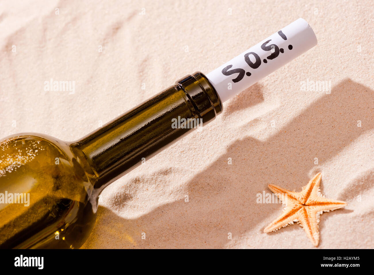 word SOS is written in the note in the bottle Stock Photo - Alamy