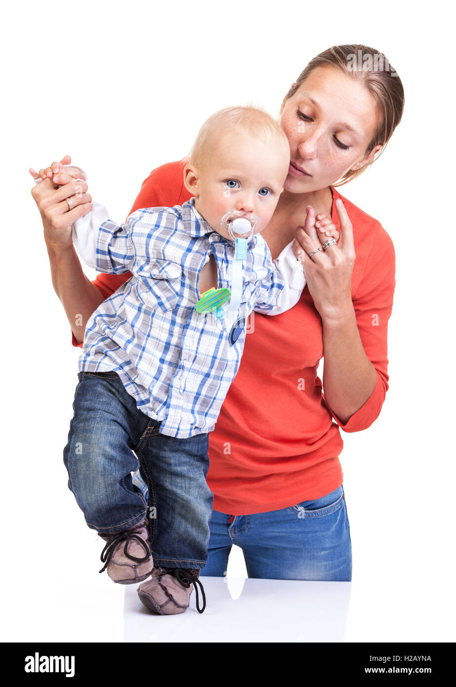 Baby boy learning to walk with mother's help Stock Photo - Alamy