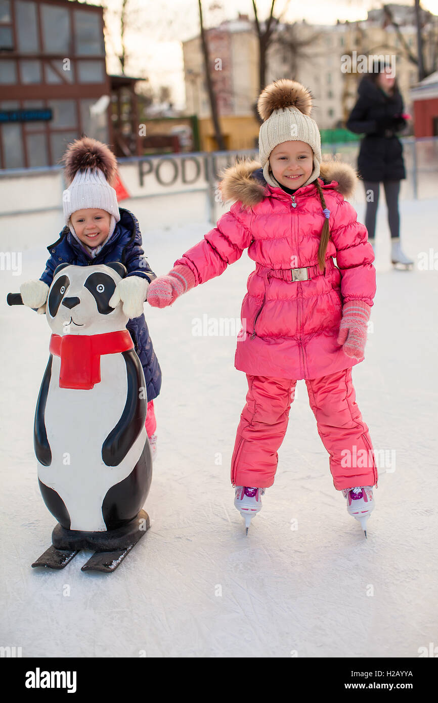 Two adorable little girls skating at the ice-rink Stock Photo - Alamy