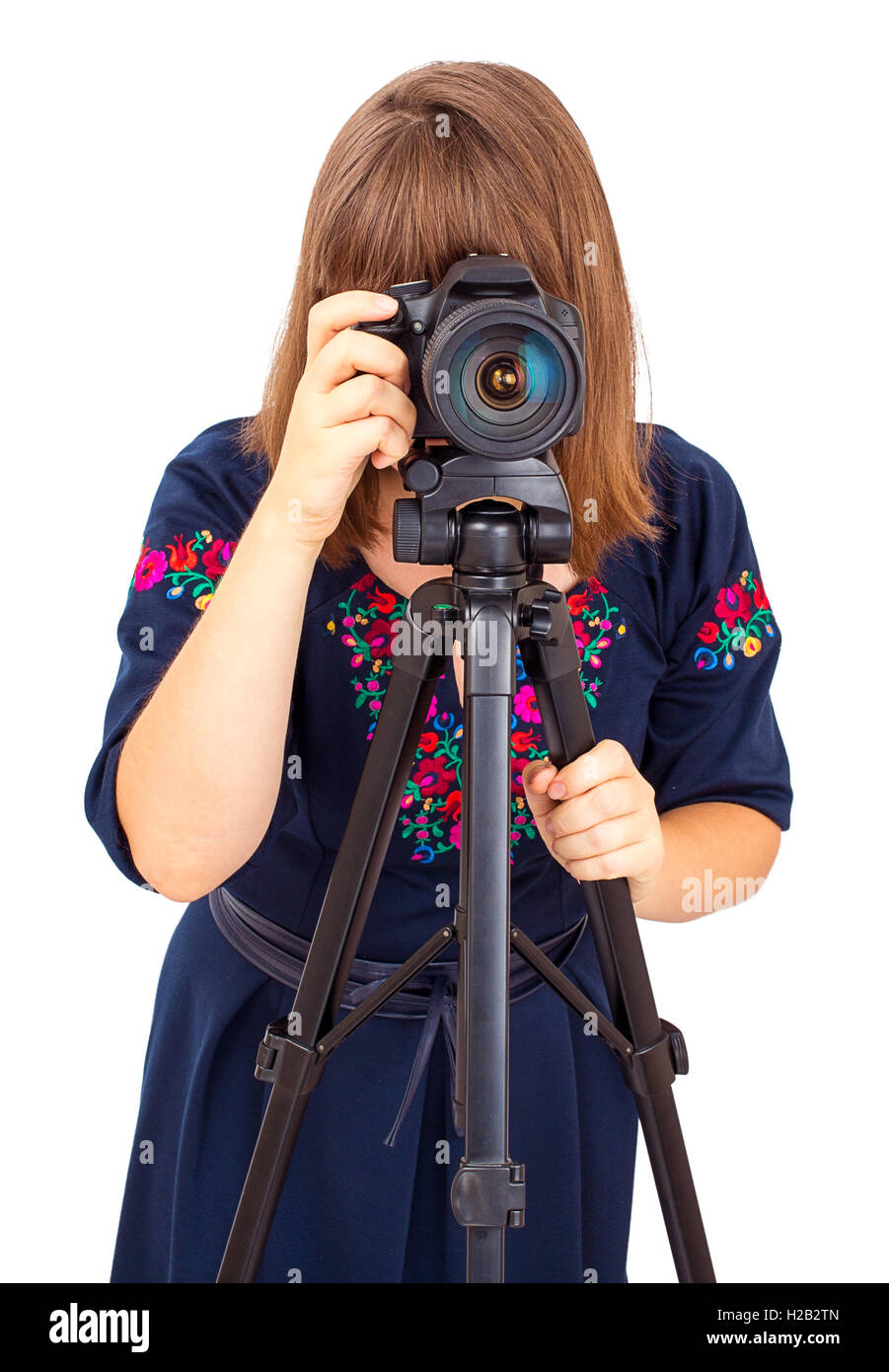Woman photographer looking into the camera lens on a tripod isolated on ...