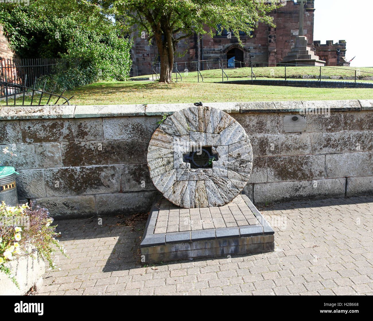 A mill stone in the street in the village of Audlem Cheshire England UK ...