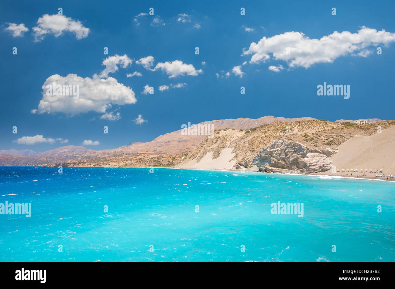 Agios Pavlos Beach in Crete island, Greece. Tourists relax and bath in crystal clear water of St ...