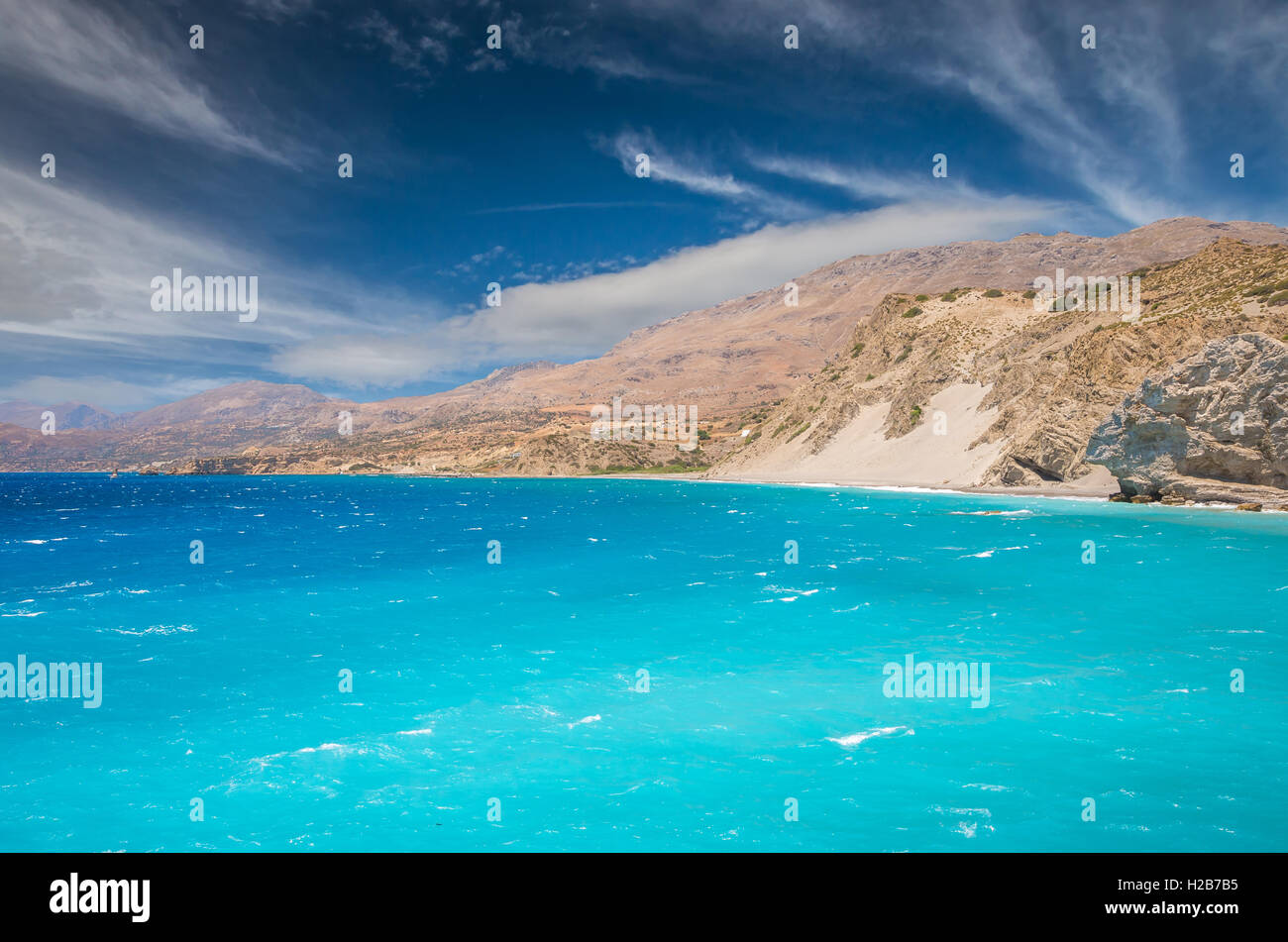 Agios Pavlos Beach in Crete island, Greece. Tourists relax and bath in crystal clear water of St ...
