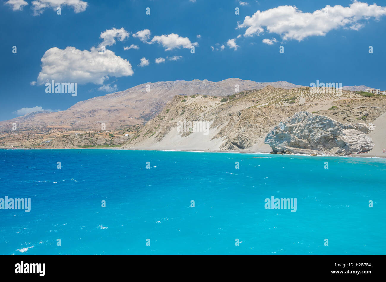 Agios Pavlos Beach in Crete island, Greece. Tourists relax and bath in crystal clear water of St ...