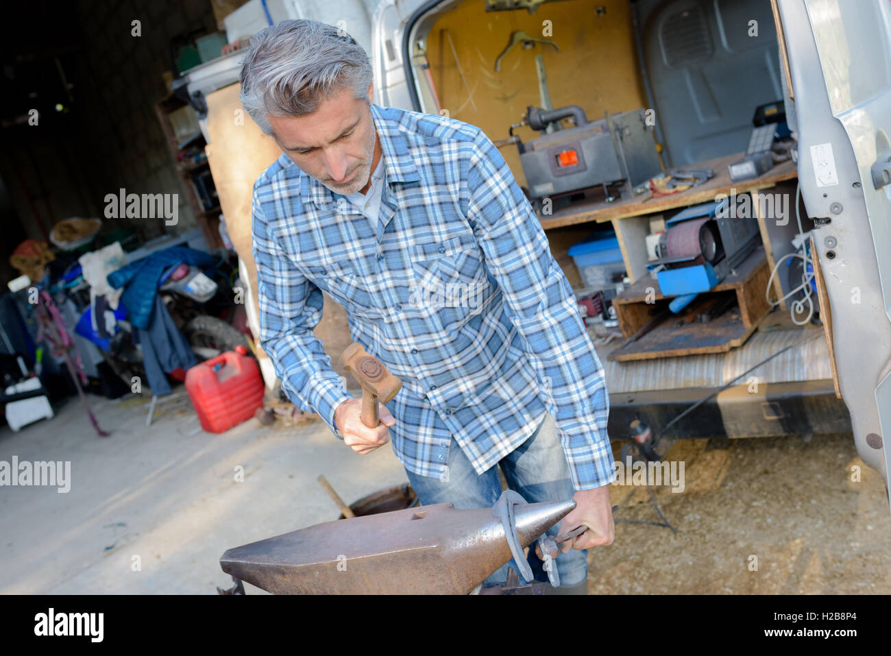 Blacksmith at work using anvil Stock Photo - Alamy