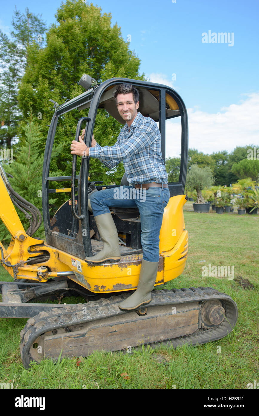 Man stood on digger with caterpillar tracks Stock Photo - Alamy