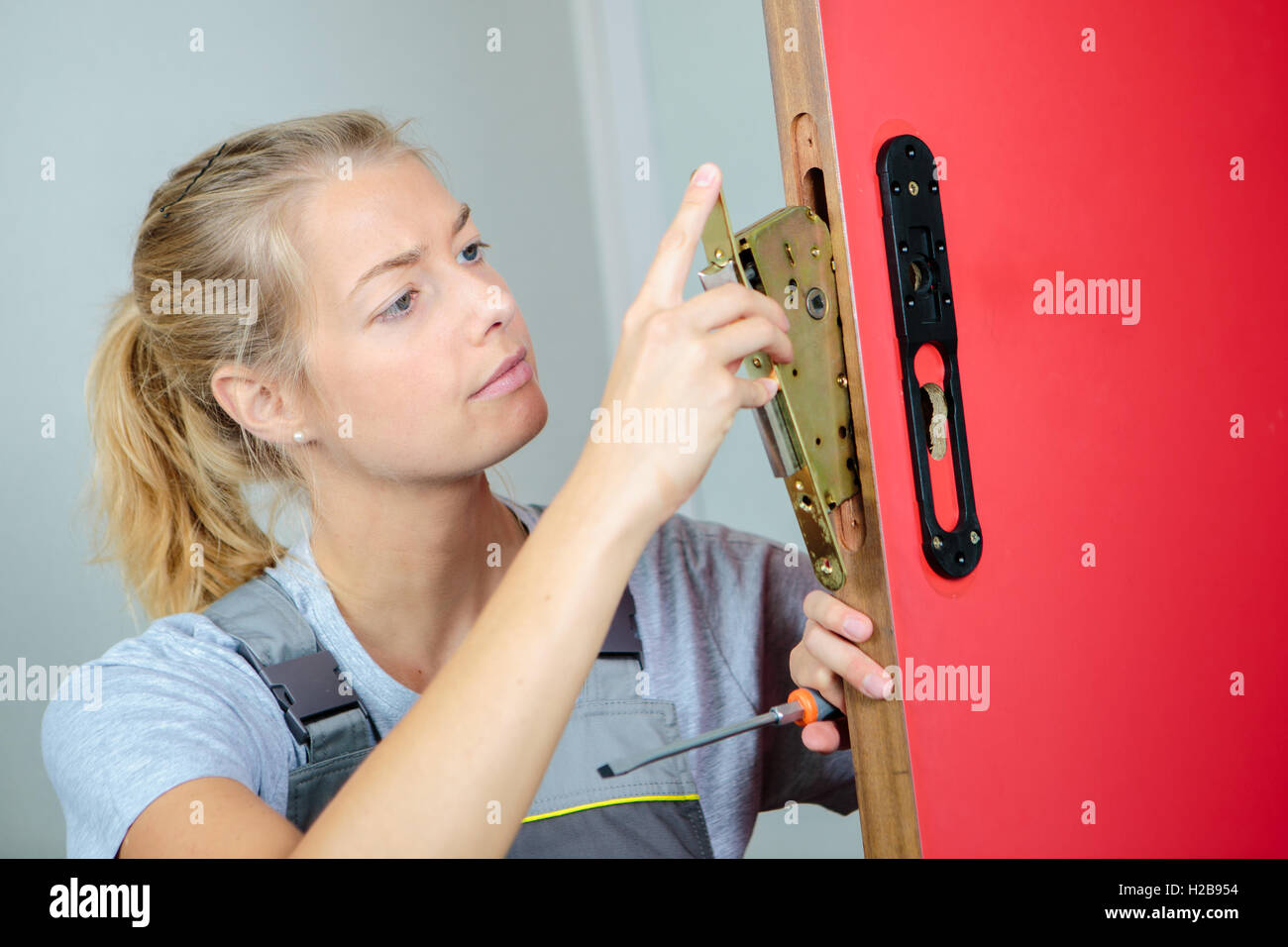 Lady fitting lock in door Stock Photo - Alamy