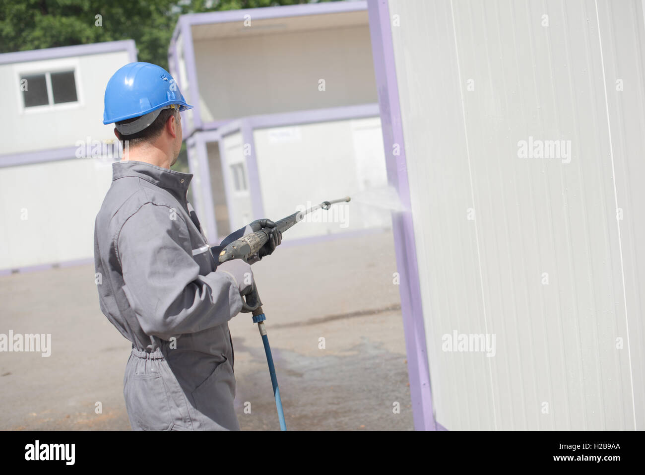 Man power washing portable cabin Stock Photo - Alamy