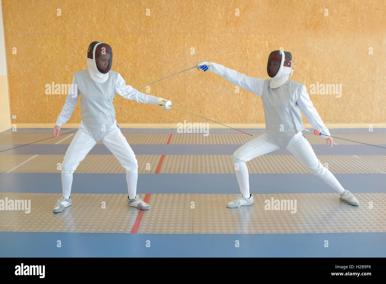 Two people in fencing joust Stock Photo - Alamy