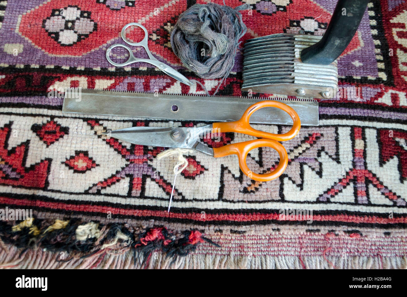 The old of worn woolen carpet with tools for the restoration Stock ...