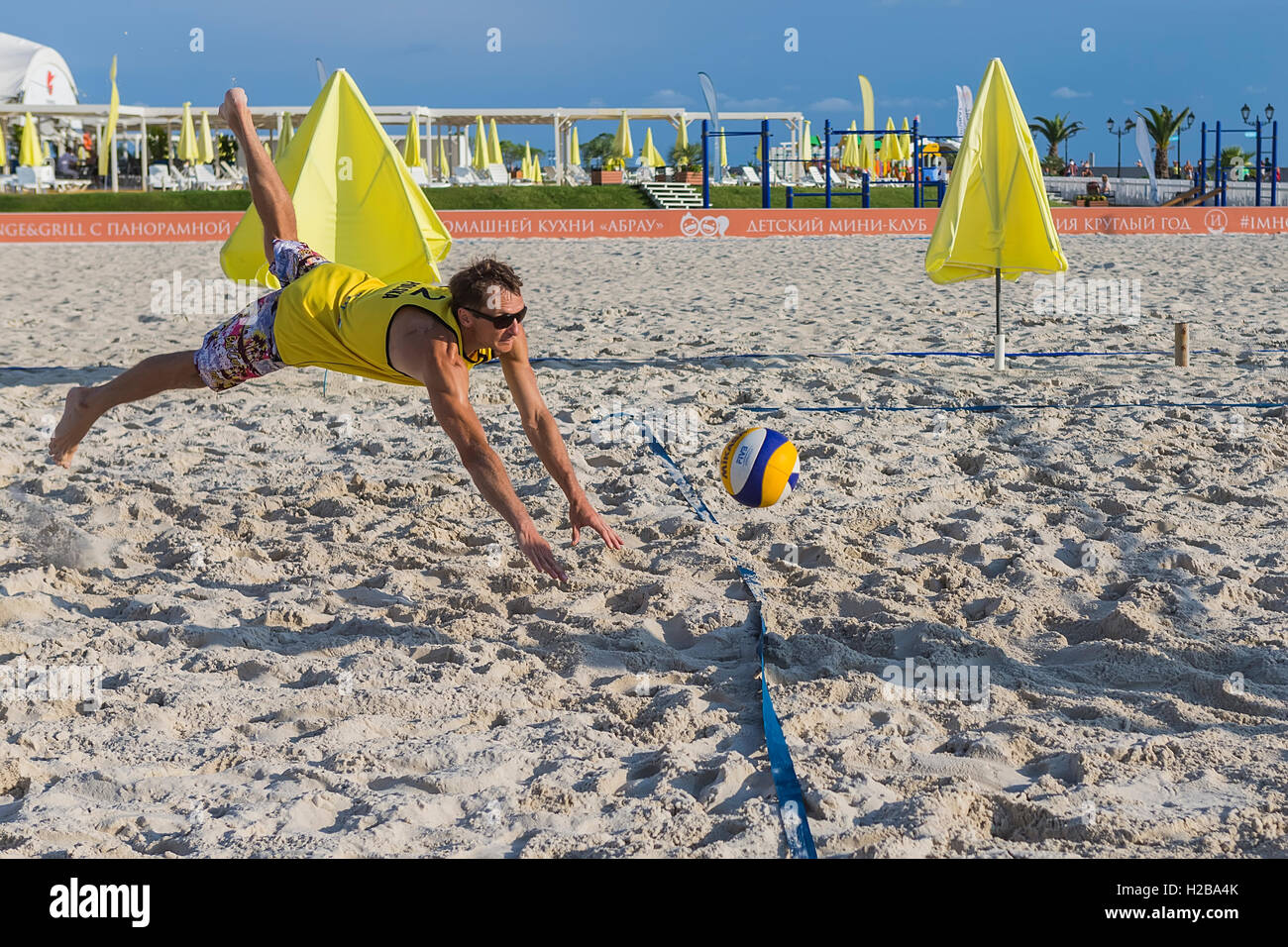 Young man in motion plays in beach volleyball Stock Photo - Alamy