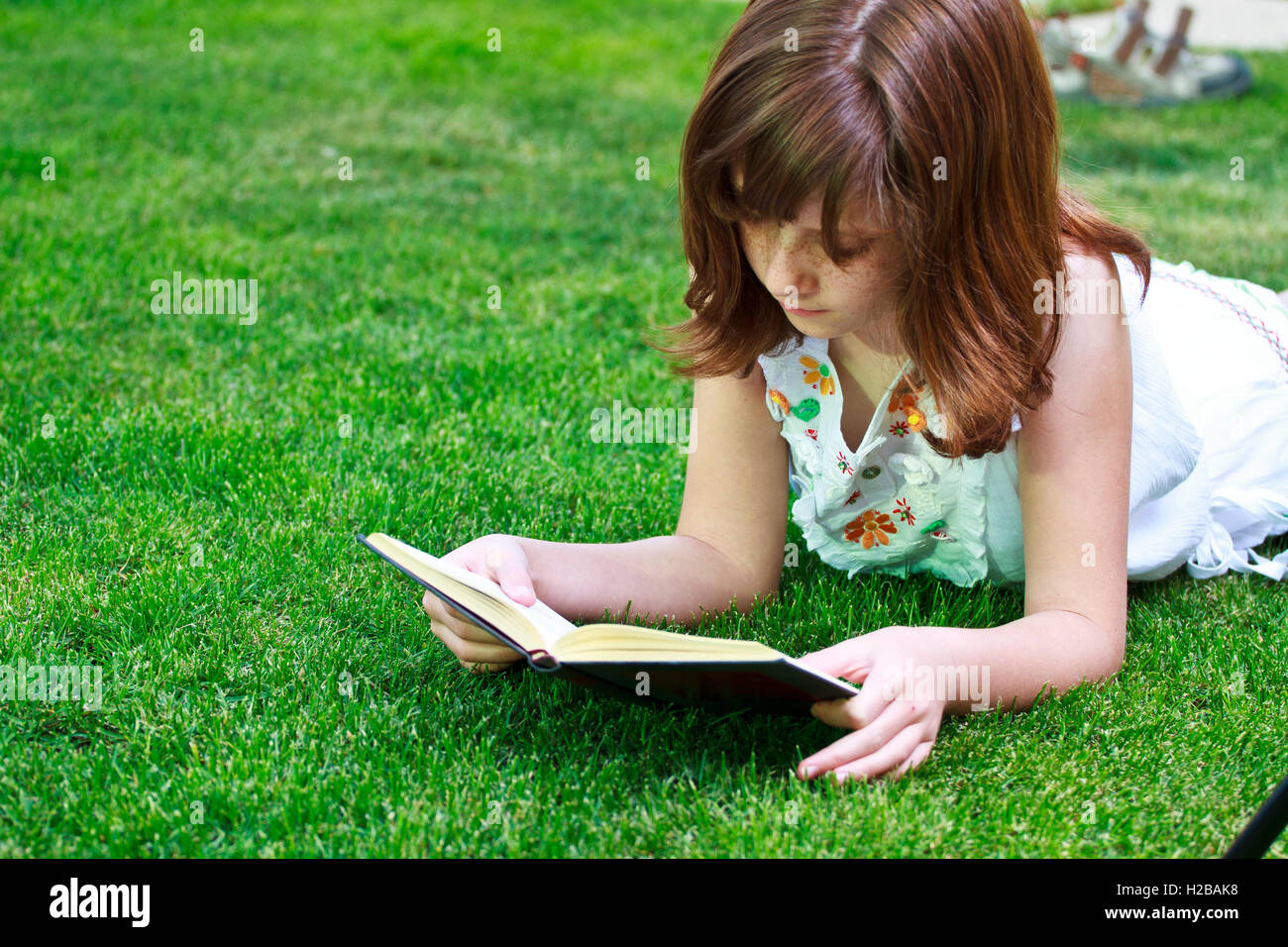 Read.Young beautiful girl reading a book outdoor Stock Photo - Alamy