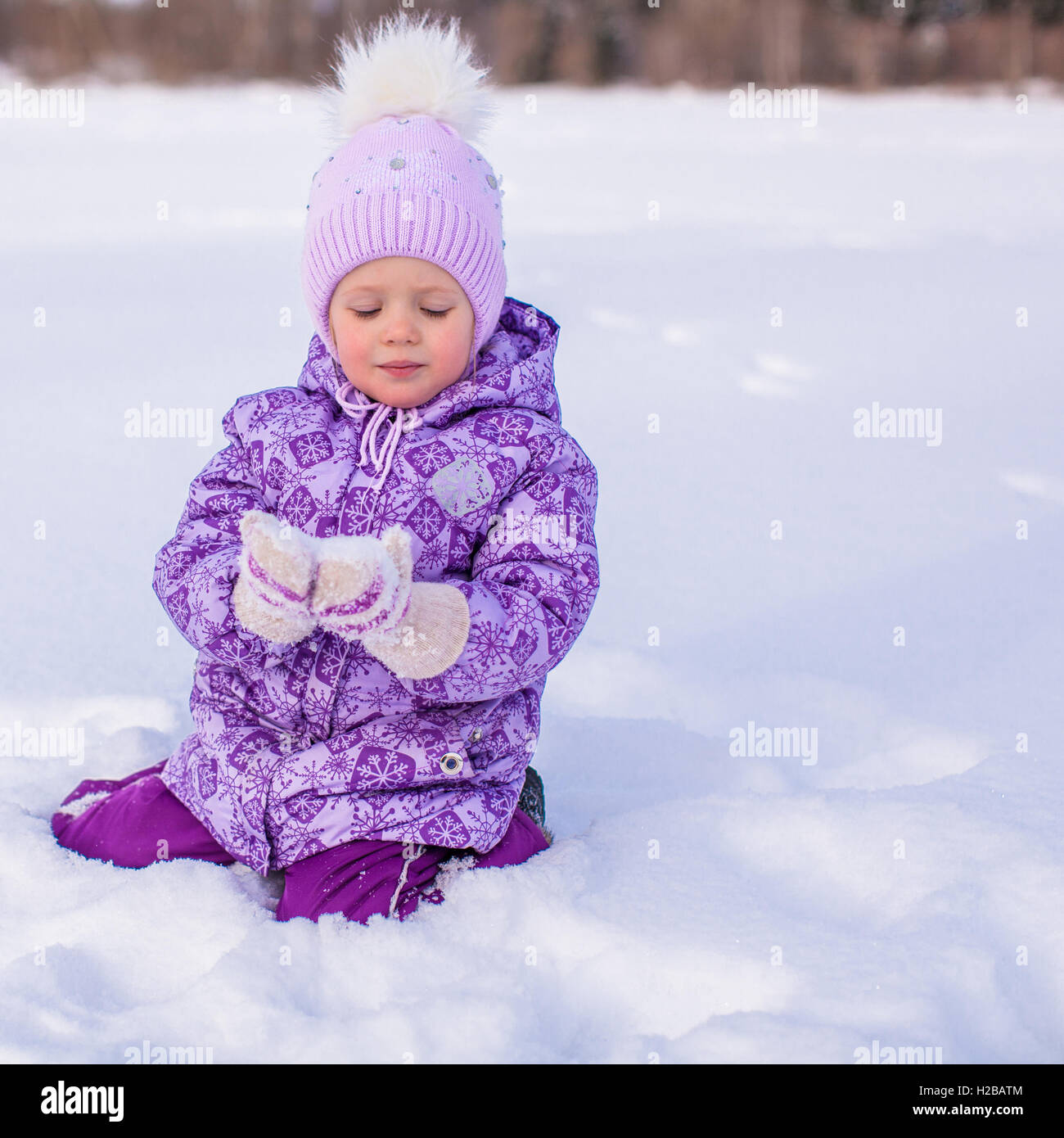 Happy little girl playing with snow at winter sunny day Stock Photo - Alamy