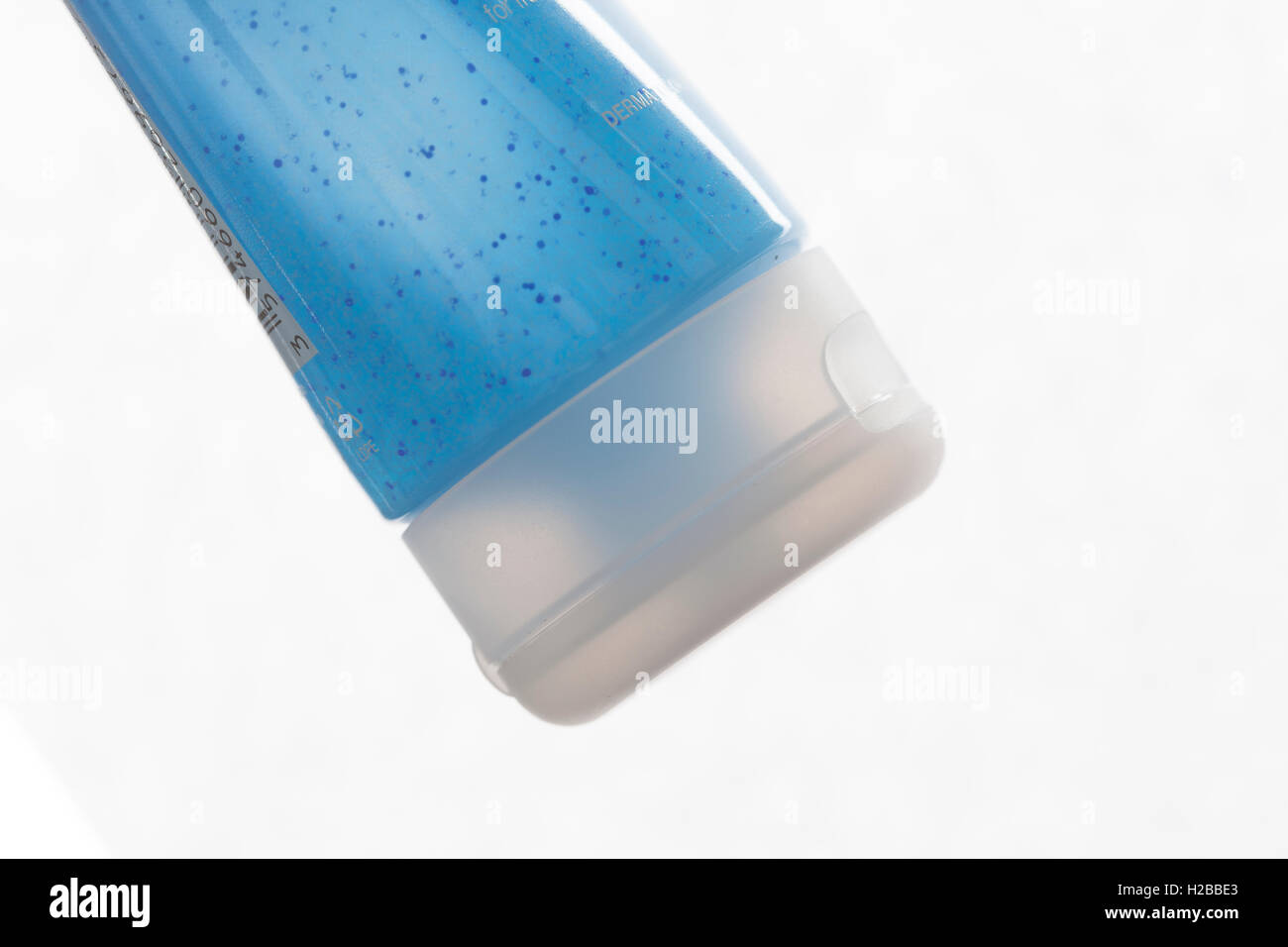 Tube of face scrub containing microbeads. Blue tube on a white ...