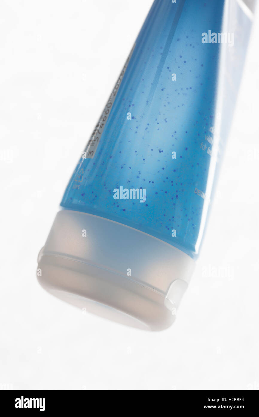 Tube of face scrub containing microbeads. Blue tube on a white ...