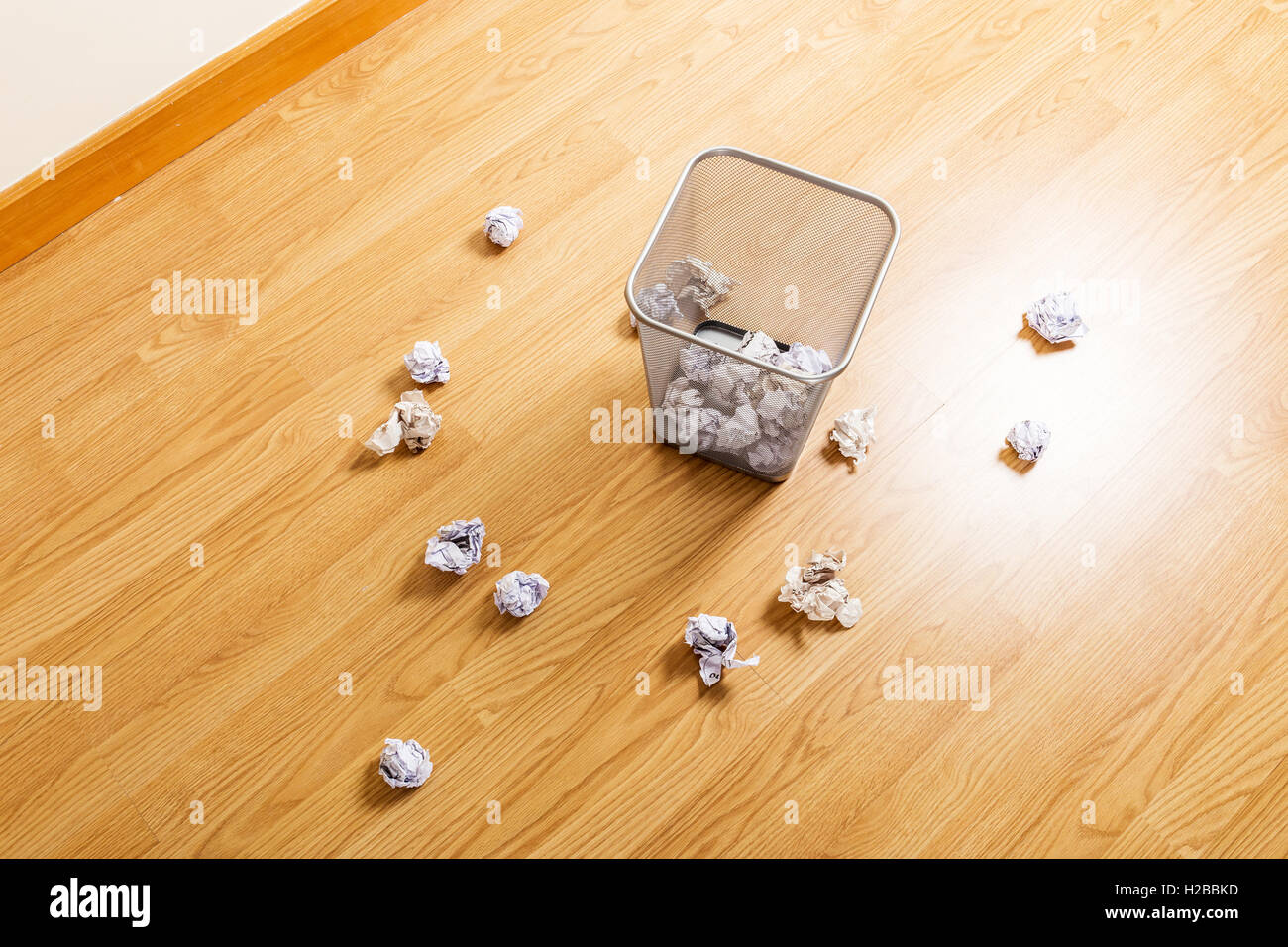 Trash bin and paper ball Stock Photo - Alamy