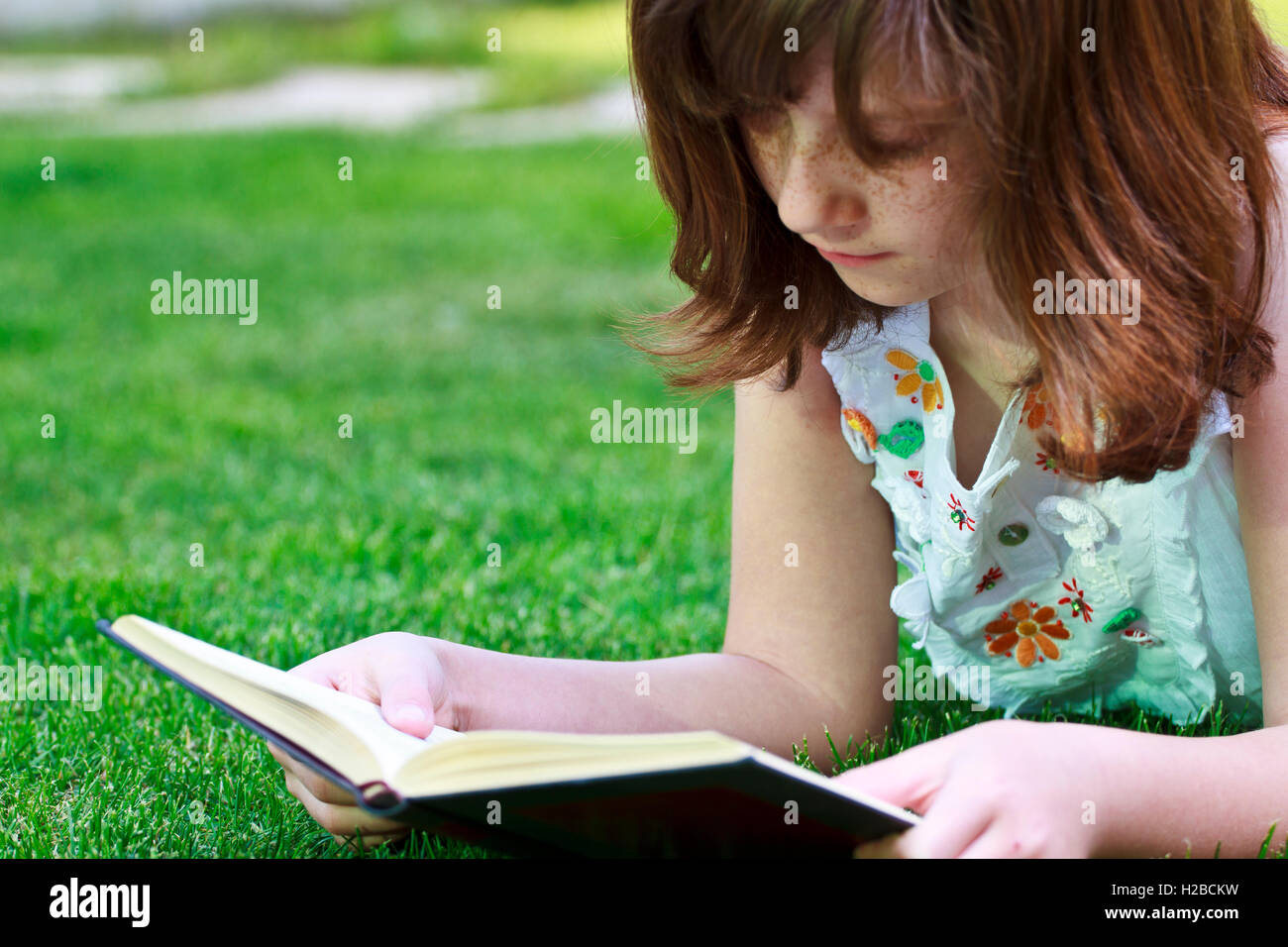 Study.Young beautiful girl reading a book outdoor Stock Photo - Alamy