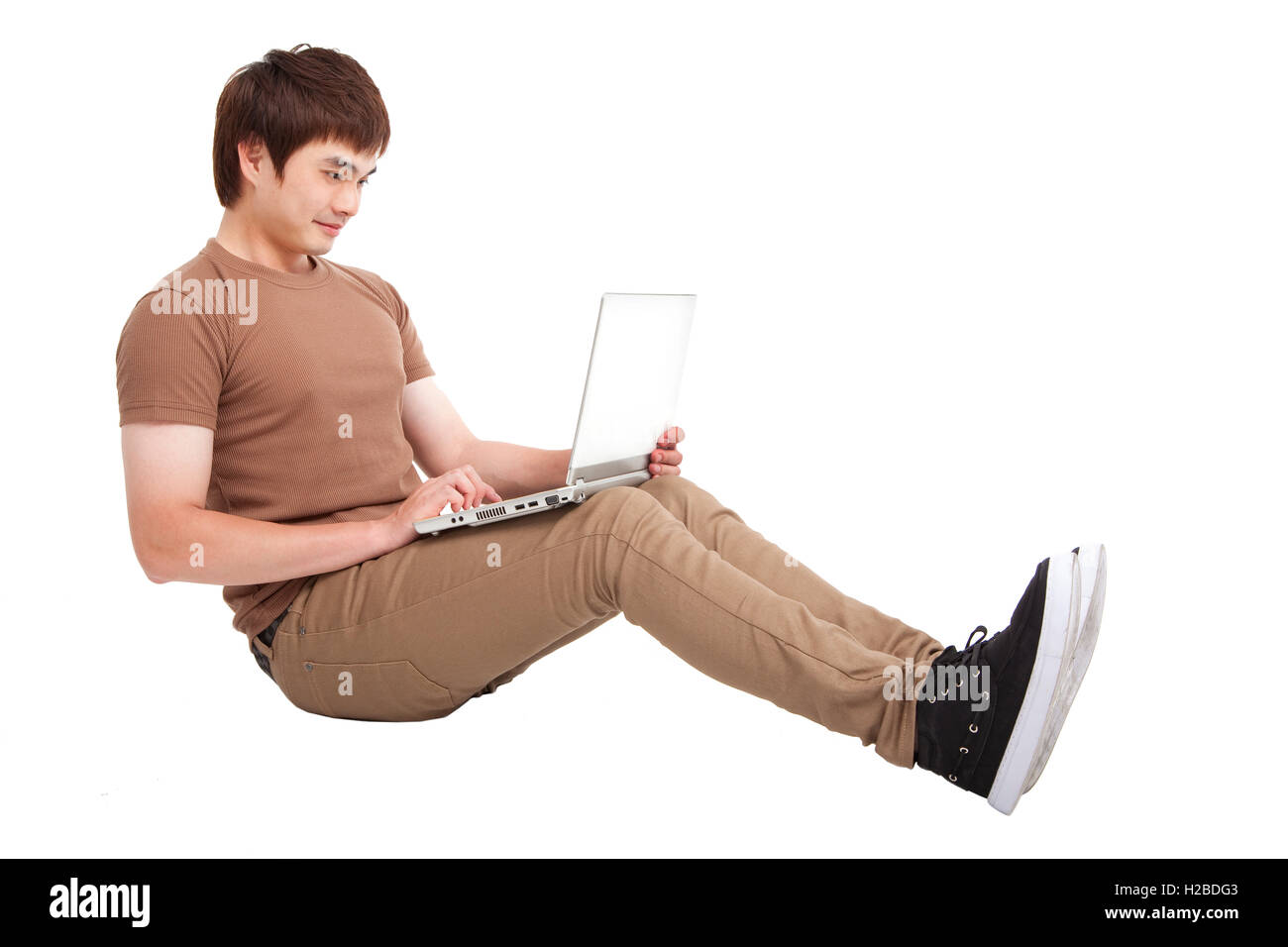 Happy young man using laptop Stock Photo - Alamy