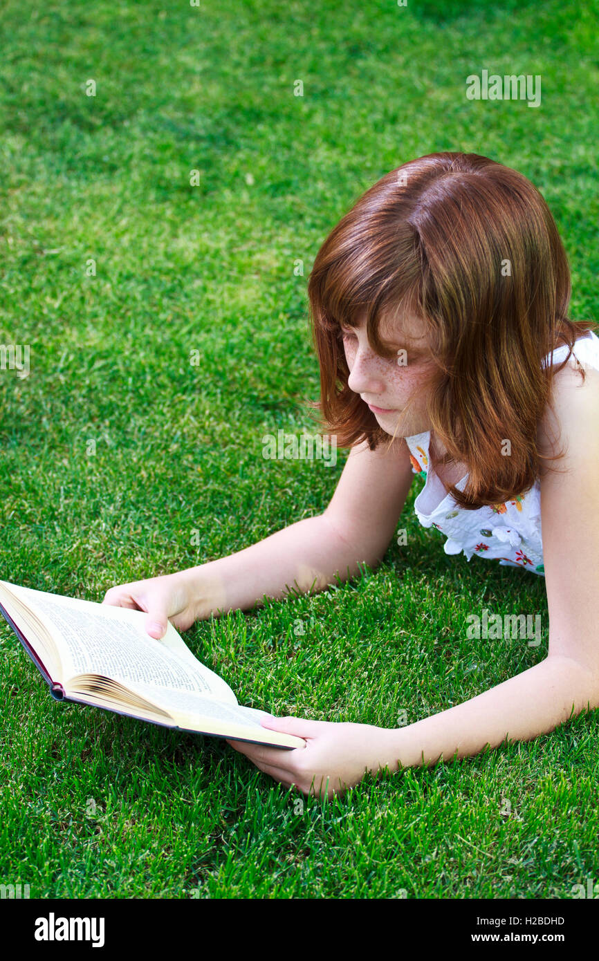 Teen.Young beautiful girl reading a book outdoor Stock Photo - Alamy