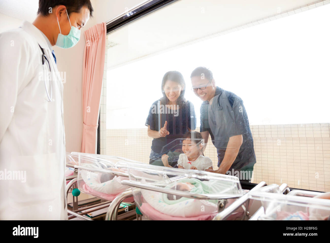 Family watching newborn in childbearing center and doctor Stock Photo ...
