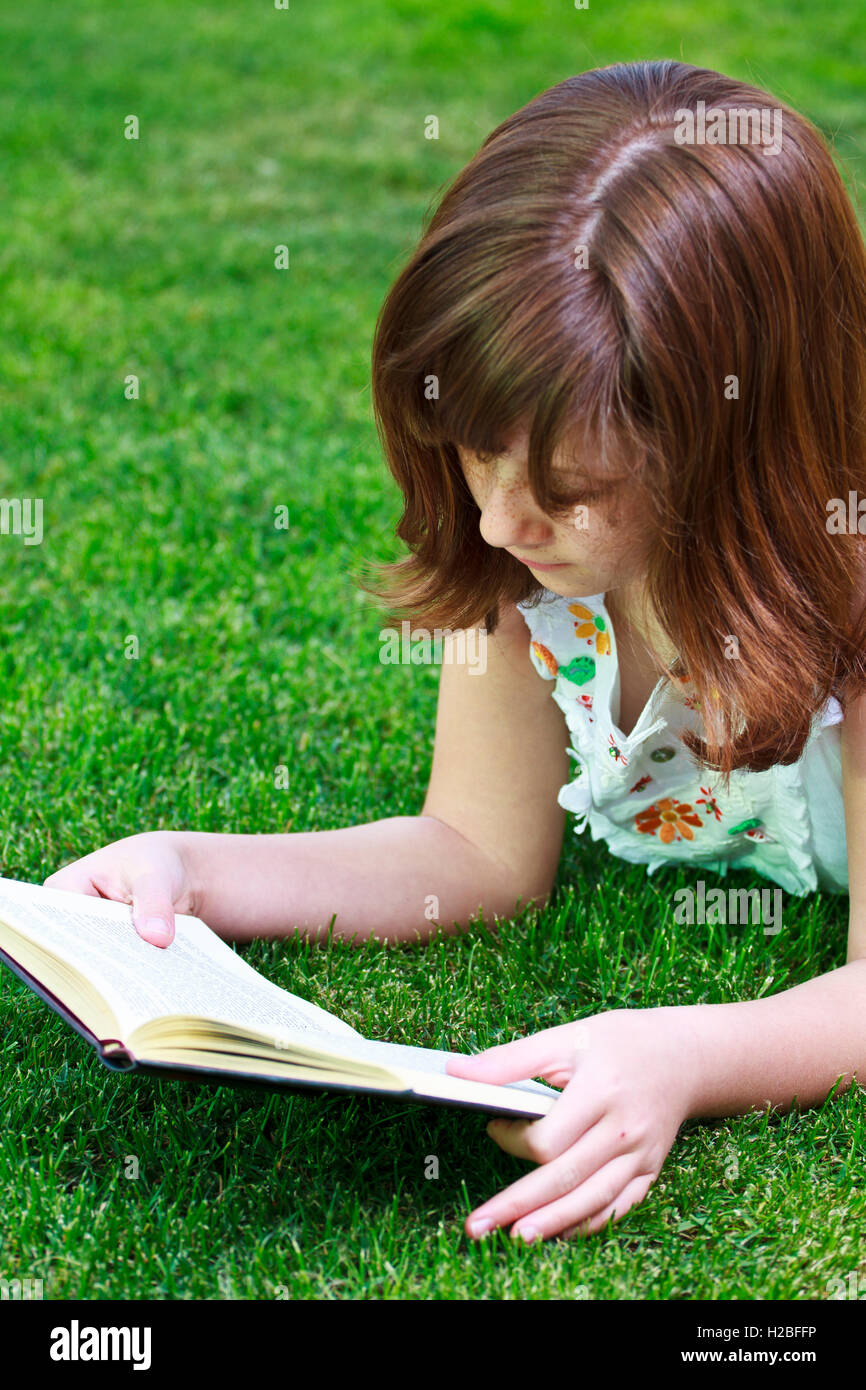 Idyllic.Young beautiful girl reading a book outdoor Stock Photo - Alamy