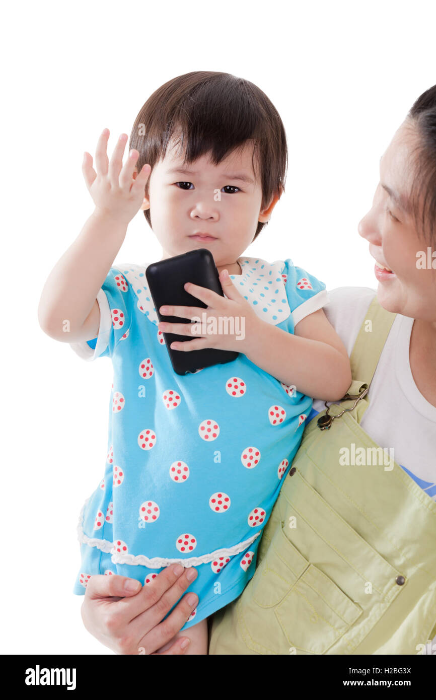 Asian mother carrying her daughter,child holding electronic gadget ...
