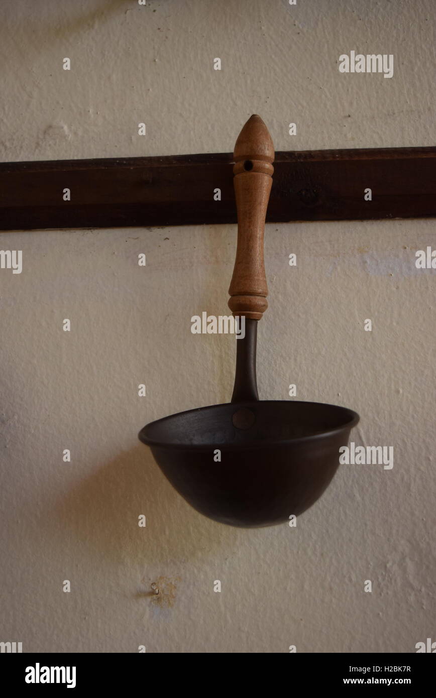 Black iron ladle hanging on white wall Stock Photo - Alamy