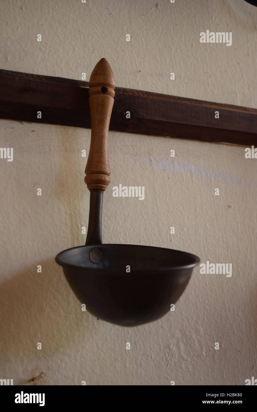 Black iron ladle hanging on white wall Stock Photo - Alamy