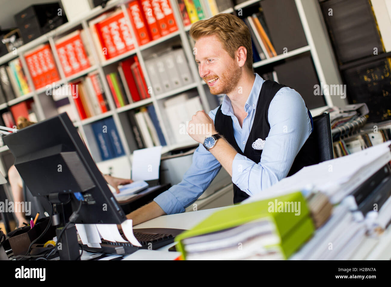 Successful young businessman at desk in office Stock Photo - Alamy