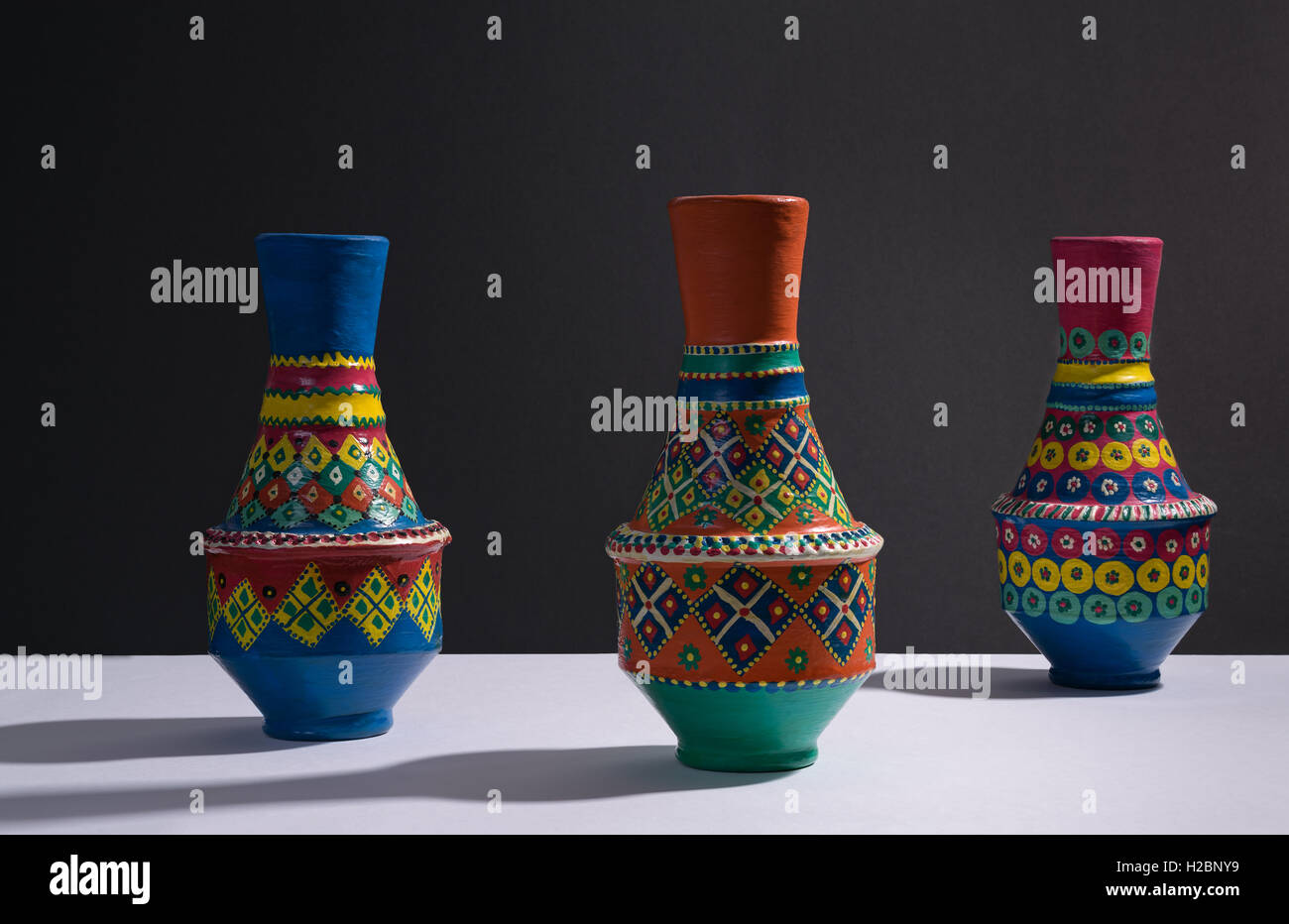 Still life of three artistic painted colorful handcrafted pottery vases ...