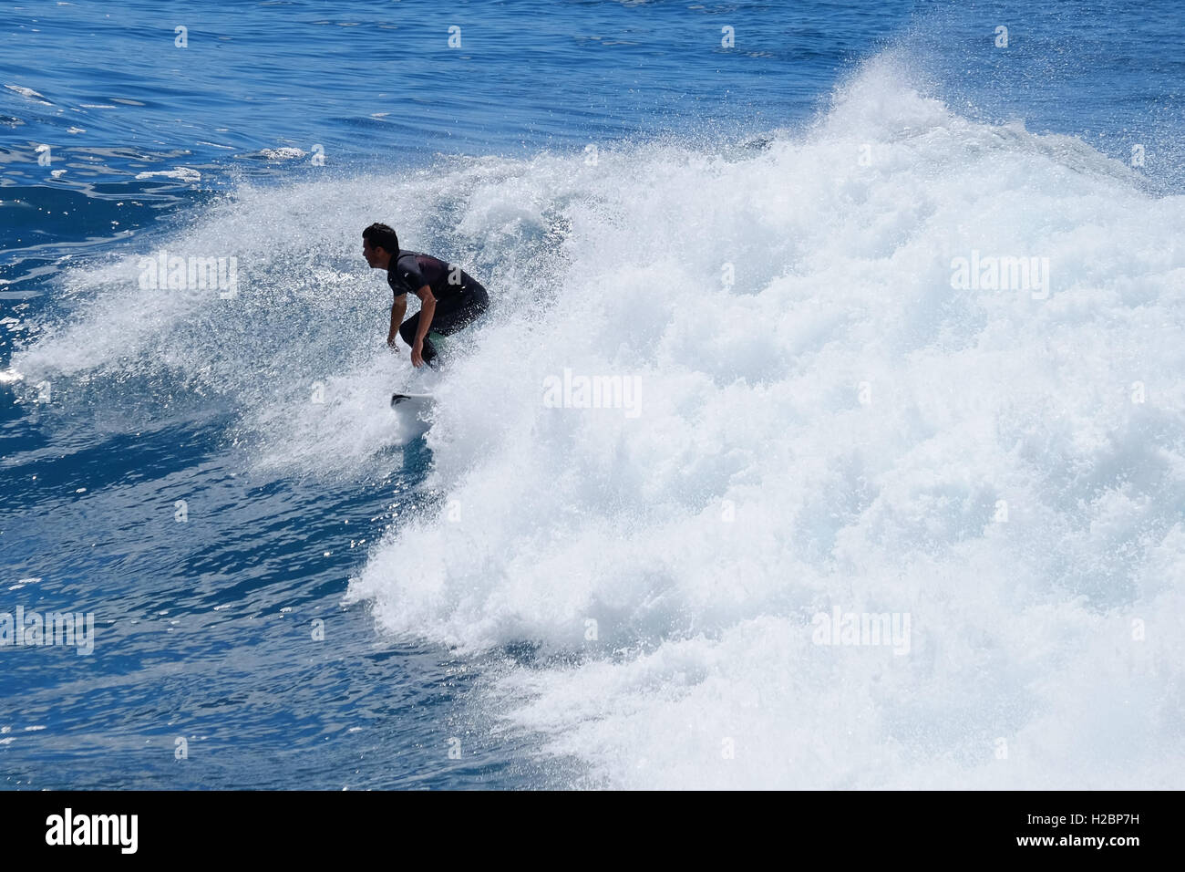 Young man surfing in the waves of the Atlantic Ocean near Jardim do Mar ...
