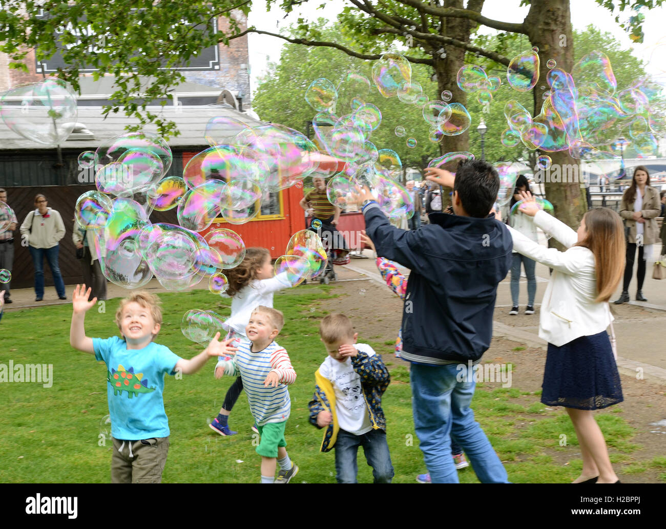 Children chasing bubbles, London South Bank Stock Photo - Alamy