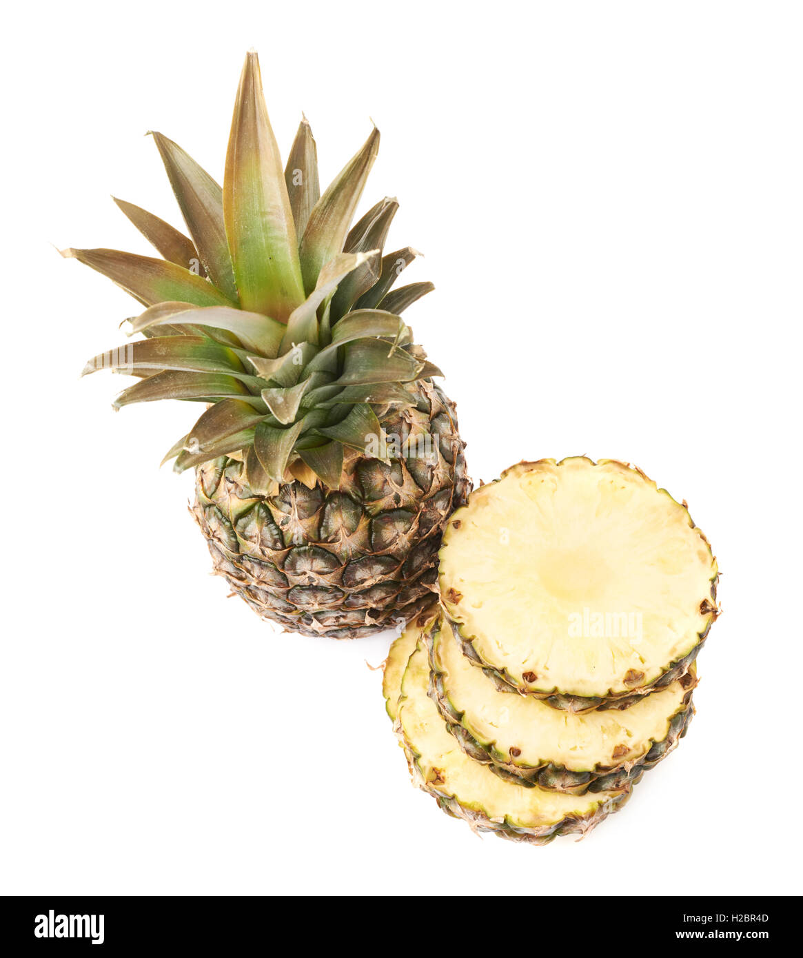 Whole pineapple with stack of slices isolated over white background ...