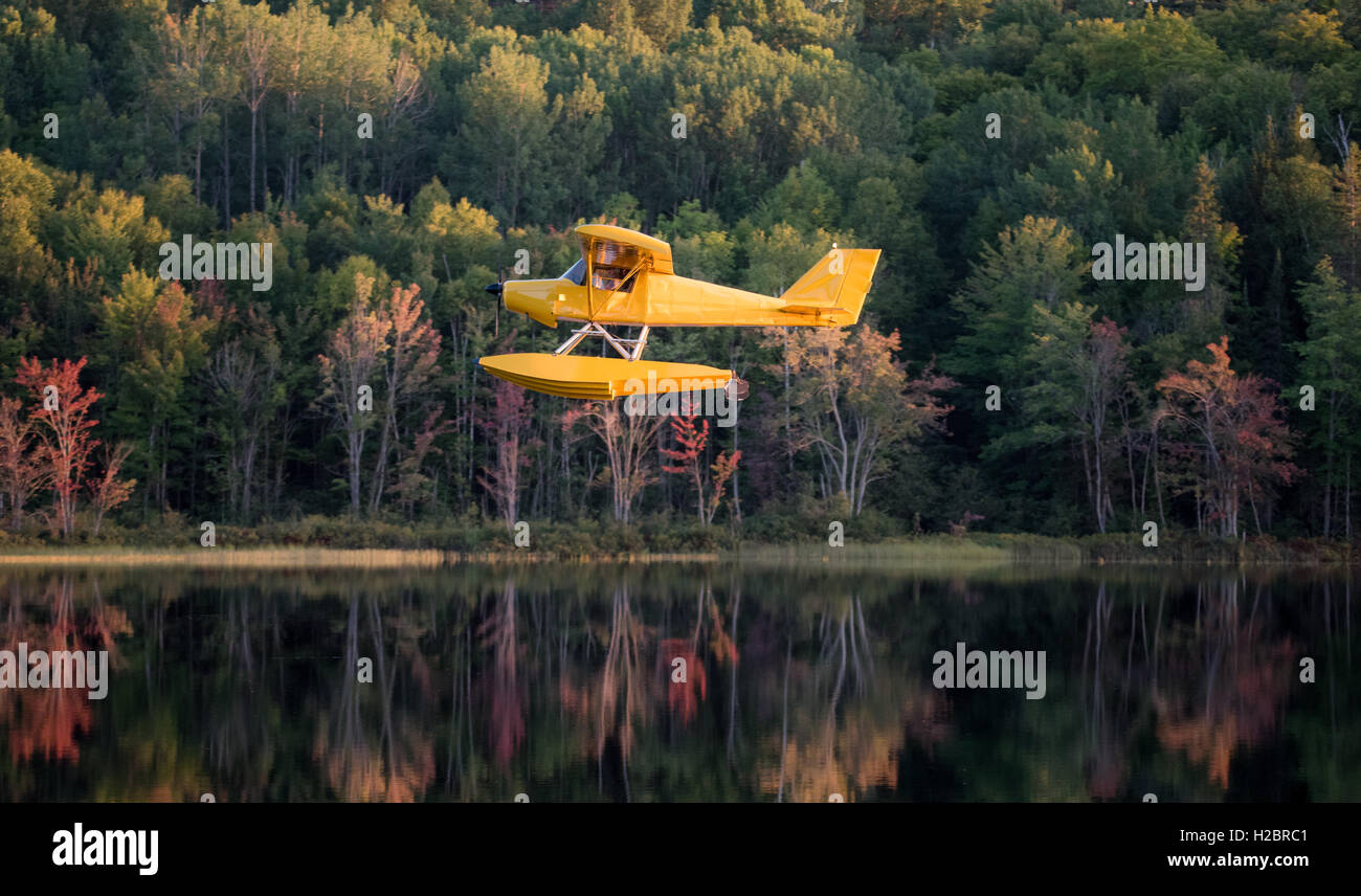 Small yellow airplane on pontoons comes in for a landing on an Eastern ...