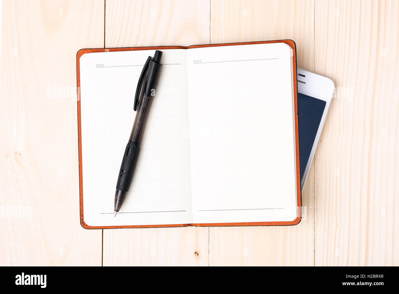 Small notepad with pen and smartphone Stock Photo - Alamy