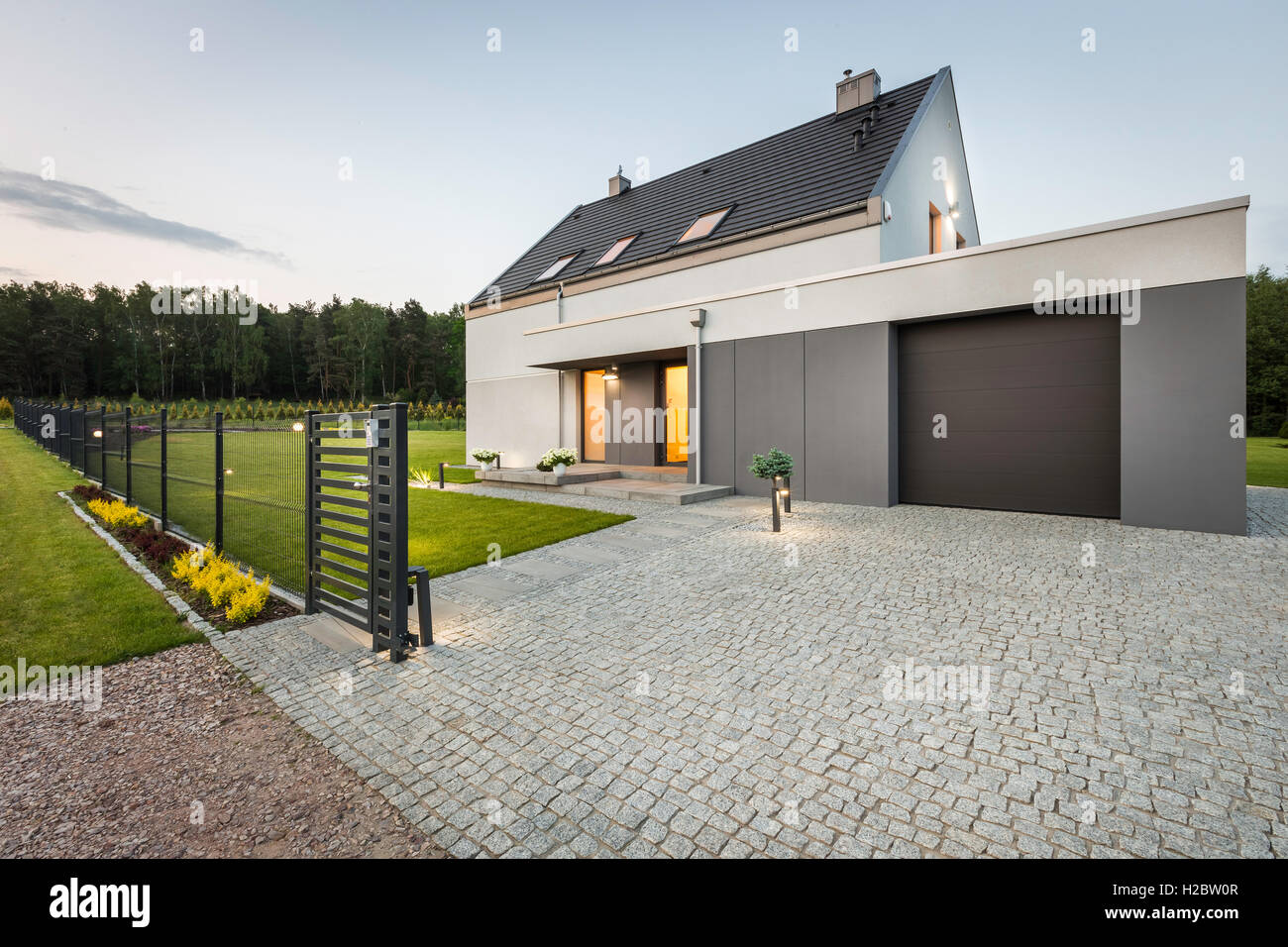 Stylish villa with fence, garage and stone driveway, external view ...