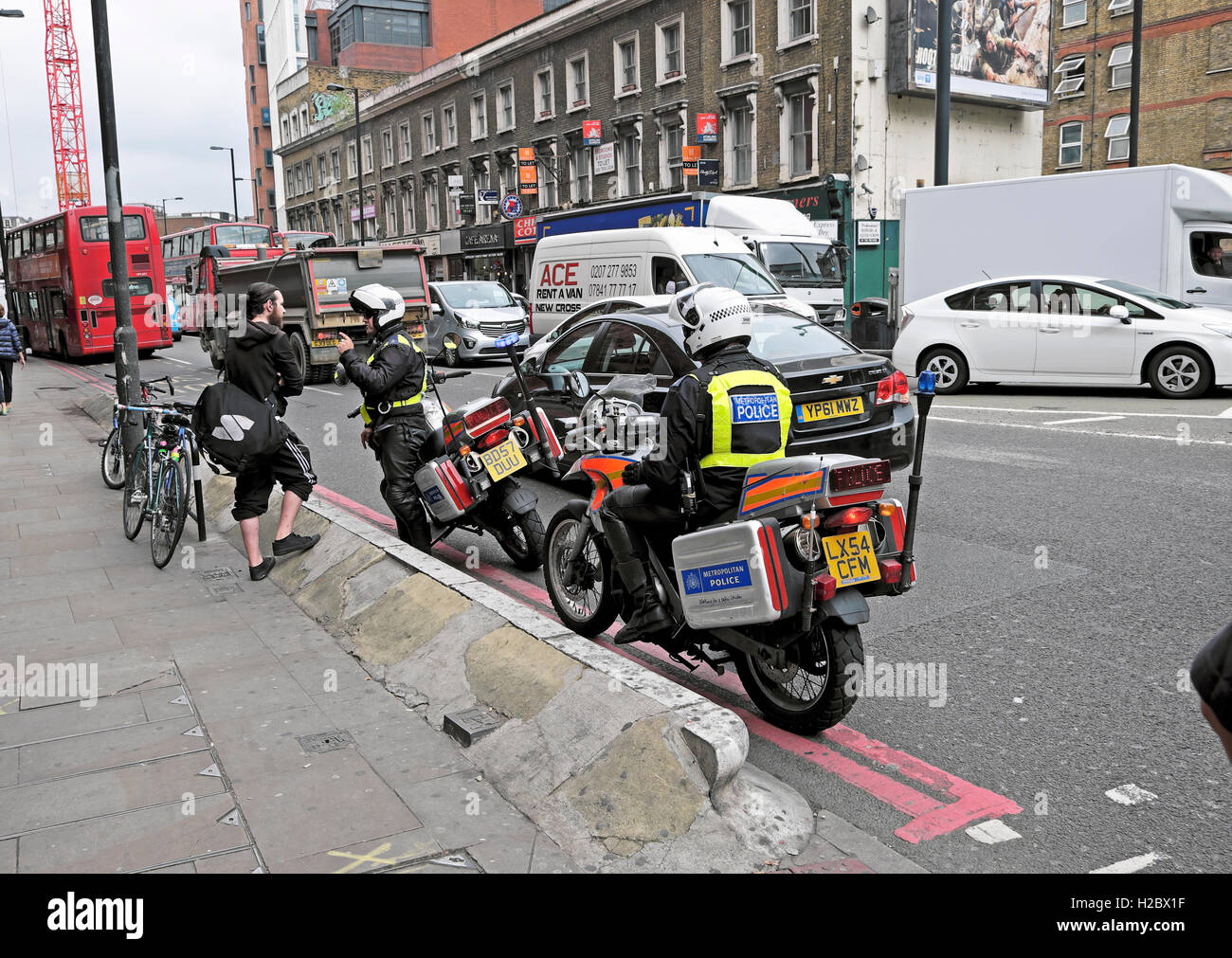 London Metropolitan Police on motorcycles stop a cyclist for traffic ...