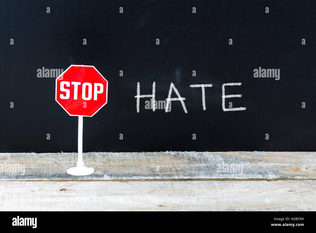 Mini STOP sign over chalkboard background and table, STOP HATE concept ...