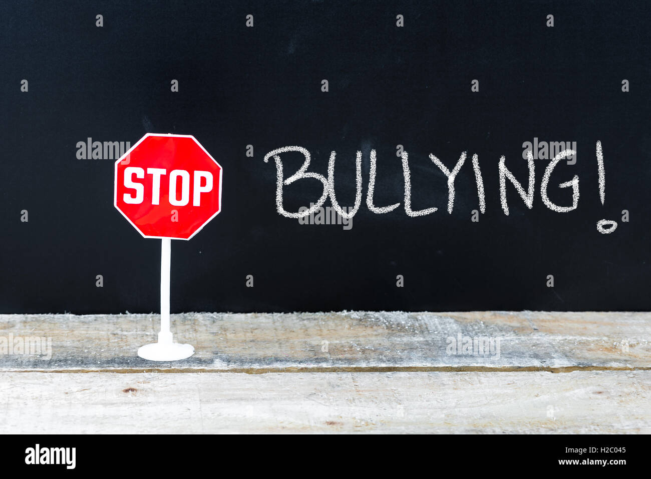 Mini STOP sign over chalkboard background and table, STOP BULLYING ...