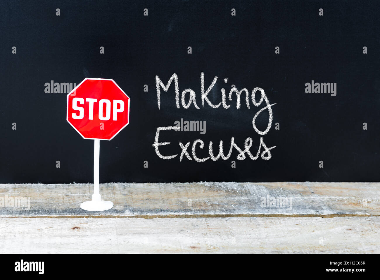 Mini STOP sign over chalkboard background and table, STOP MAKING ...