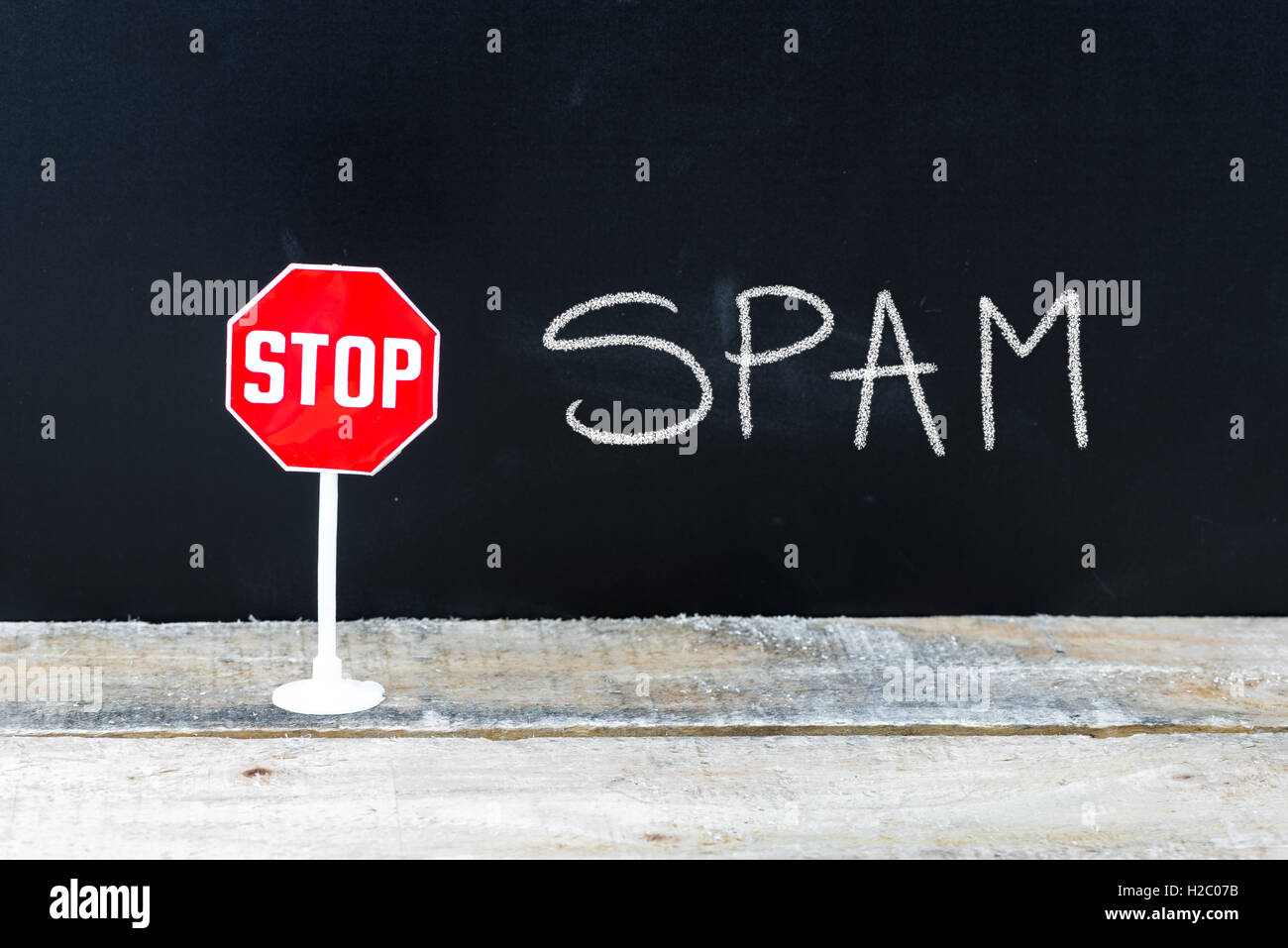 Mini STOP sign over chalkboard background and table, STOP SPAM concept ...