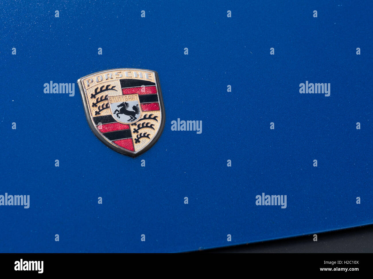 Porsche sign on the blue car hood Stock Photo - Alamy